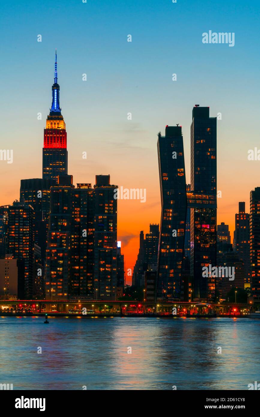 The sun sets to Manhattan skyscraper beyond the East River Stock Photo ...