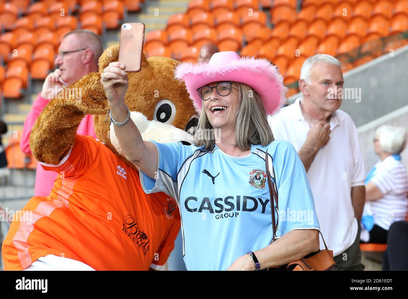 Coventry City fan takes a photo with the Blackpool mascot Bloomfield ...