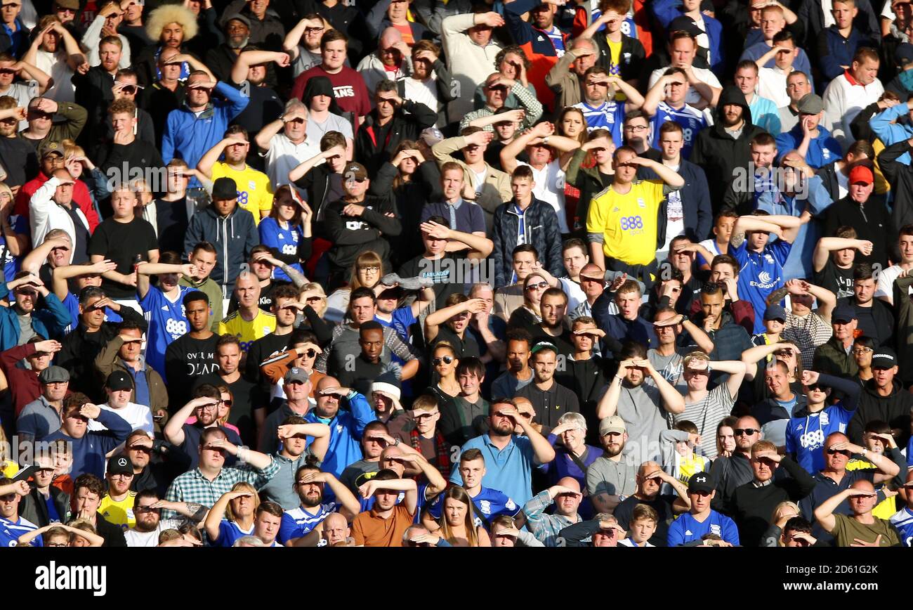 Football fans shield their eyes from the sun in the hi-res stock ...