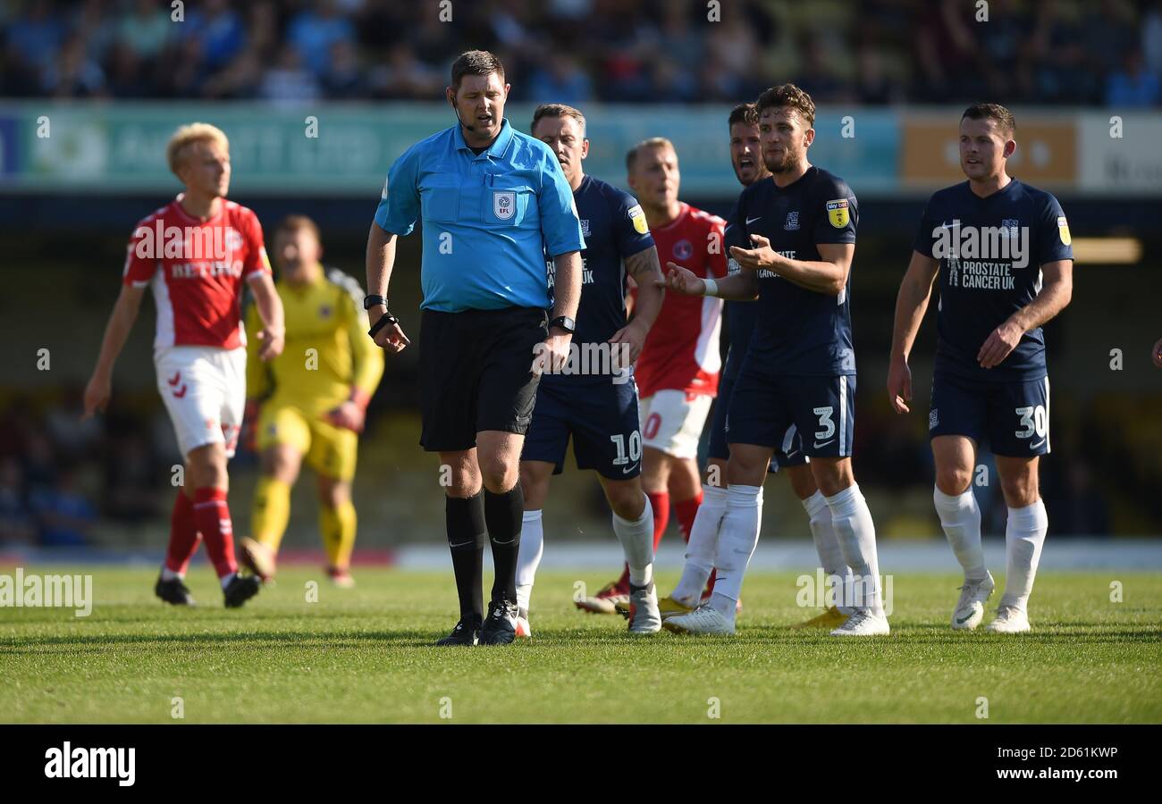 Referee Brett Huxtable is surrounded by players from both teams Stock ...