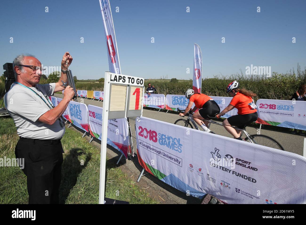 A race official hits a chime to signify the final lap during the Para ...