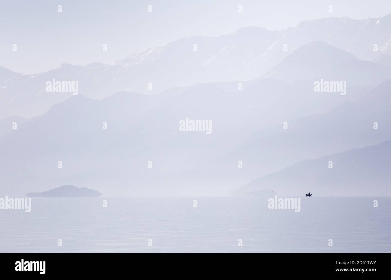 Idyllic mountain lake view with distant fishing boat Stock Photo - Alamy