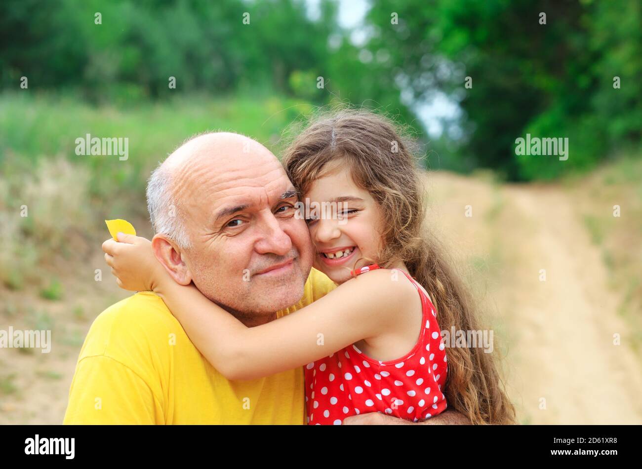 Portrait of granddad and granddaughter smiling at the park Stock Photo ...