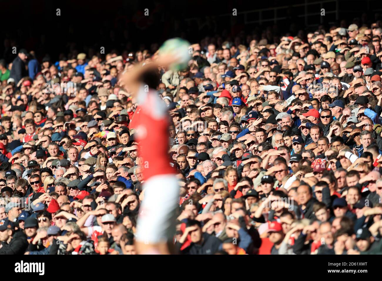 Arsenal fans in the stands shield their eyes from the sun Stock Photo ...