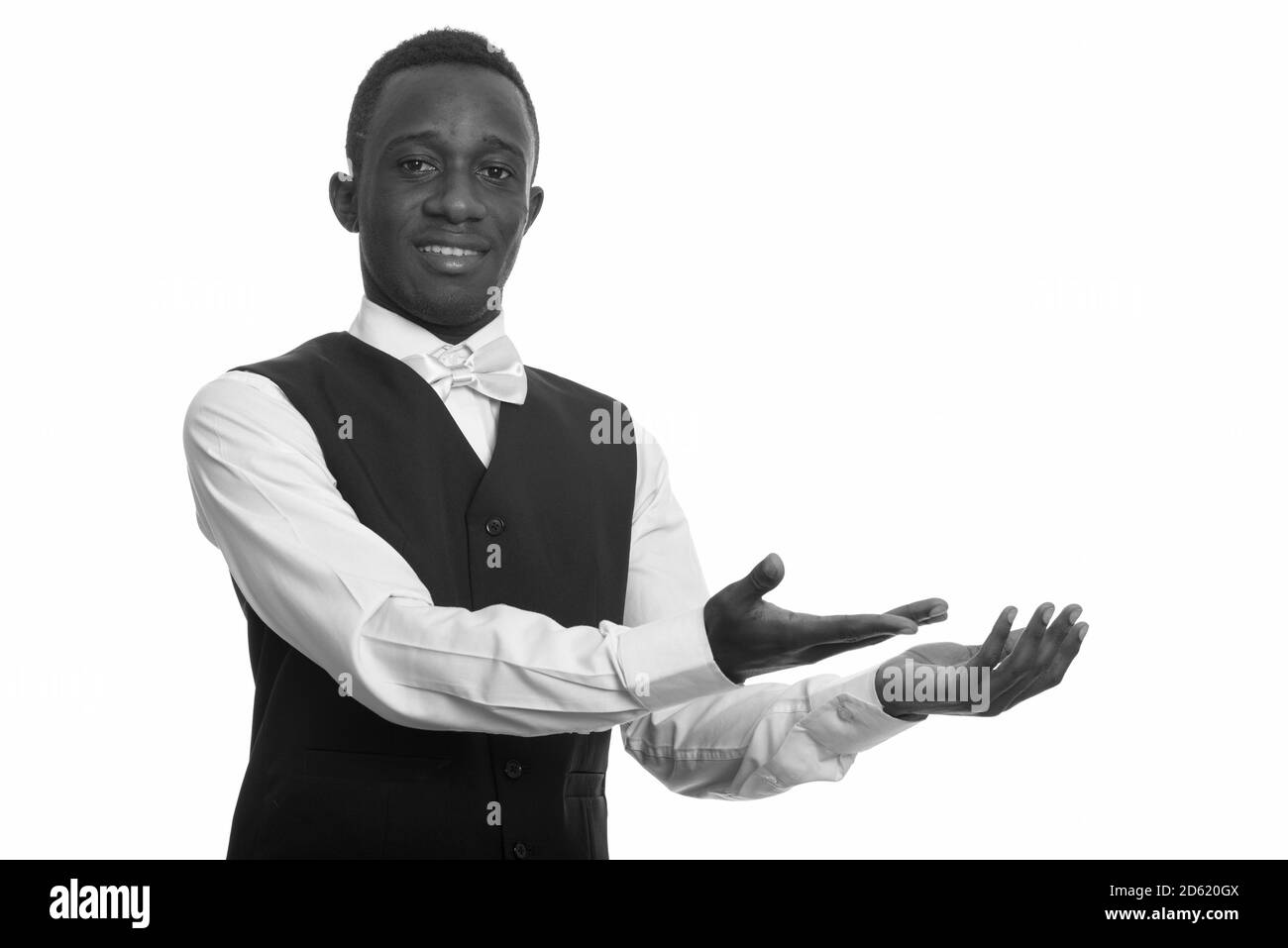 Young happy African waiter smiling and showing something Stock Photo ...