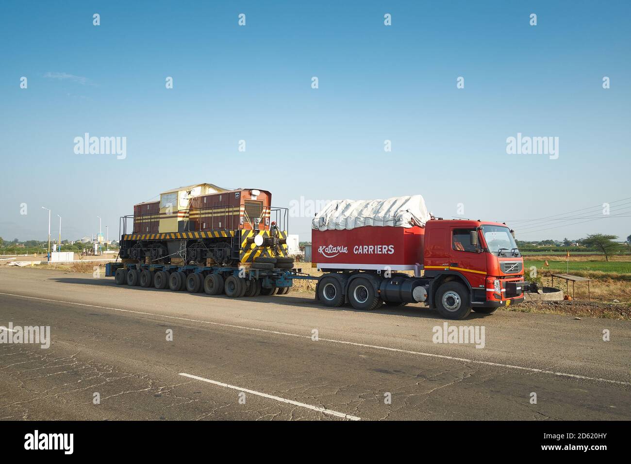 A Volvo puller truck pulling a diesel locomotive engine somewhere in ...
