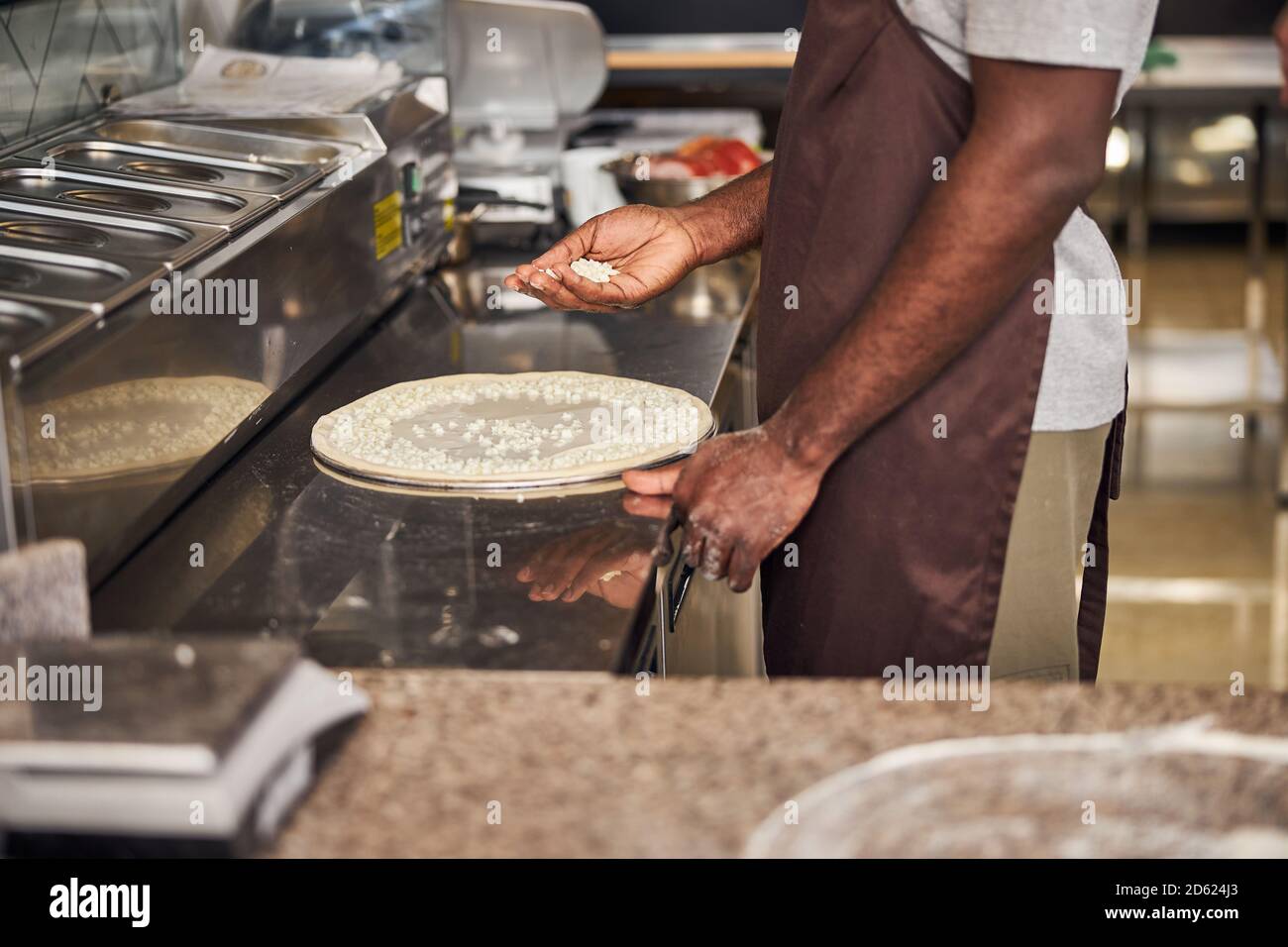 Afro American man cooking pizza in restaurant Stock Photo - Alamy