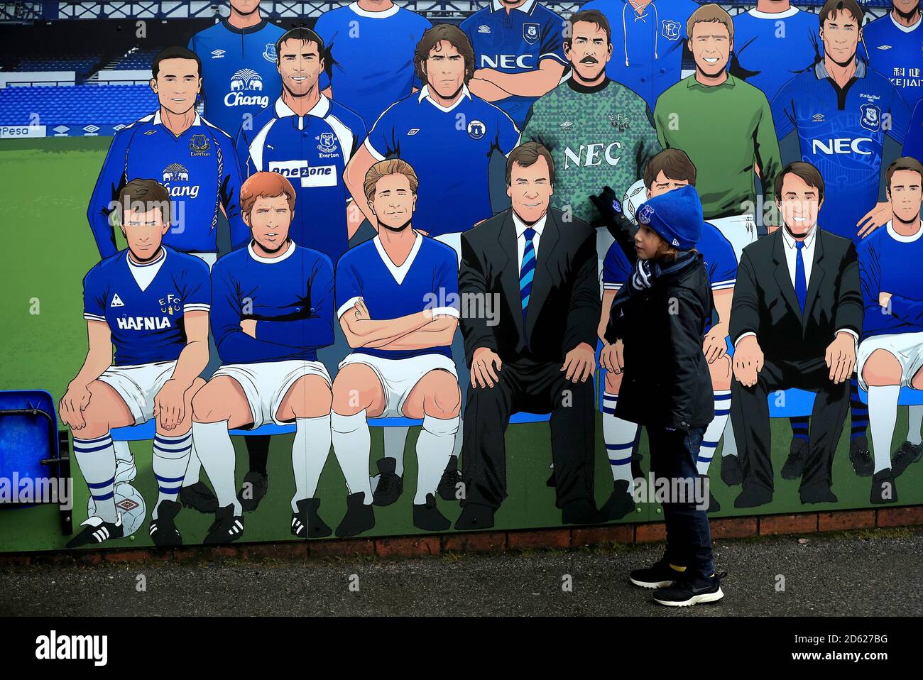 An Everton fan poses with a mural of former players outside Goodison ...