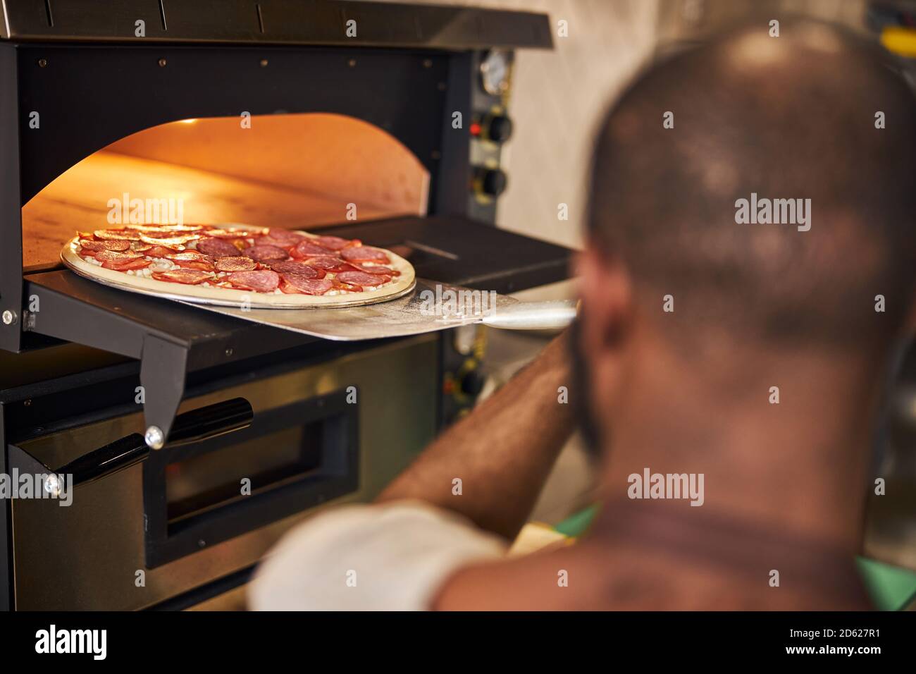 Afro American man making pizza in restaurant Stock Photo - Alamy