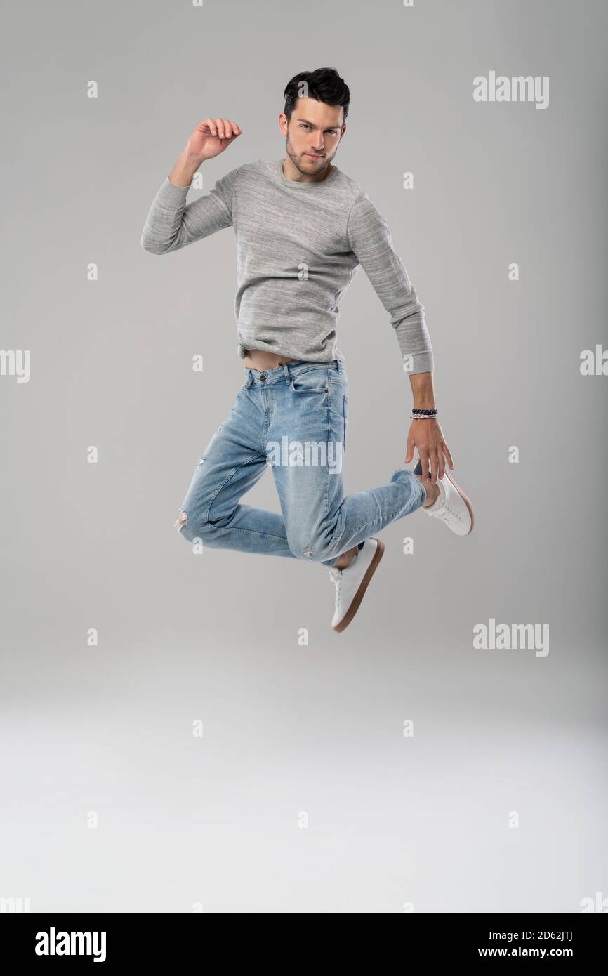 Handsome young man running or jumping in air on white background Stock ...