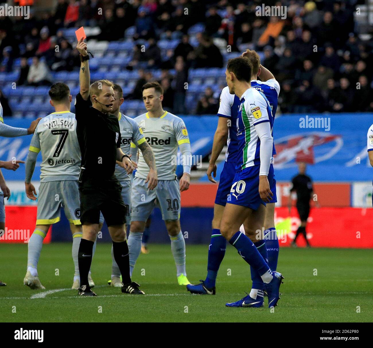 Referee Gavin Ward (left) shows a straight red card to Wigan Athletic's ...