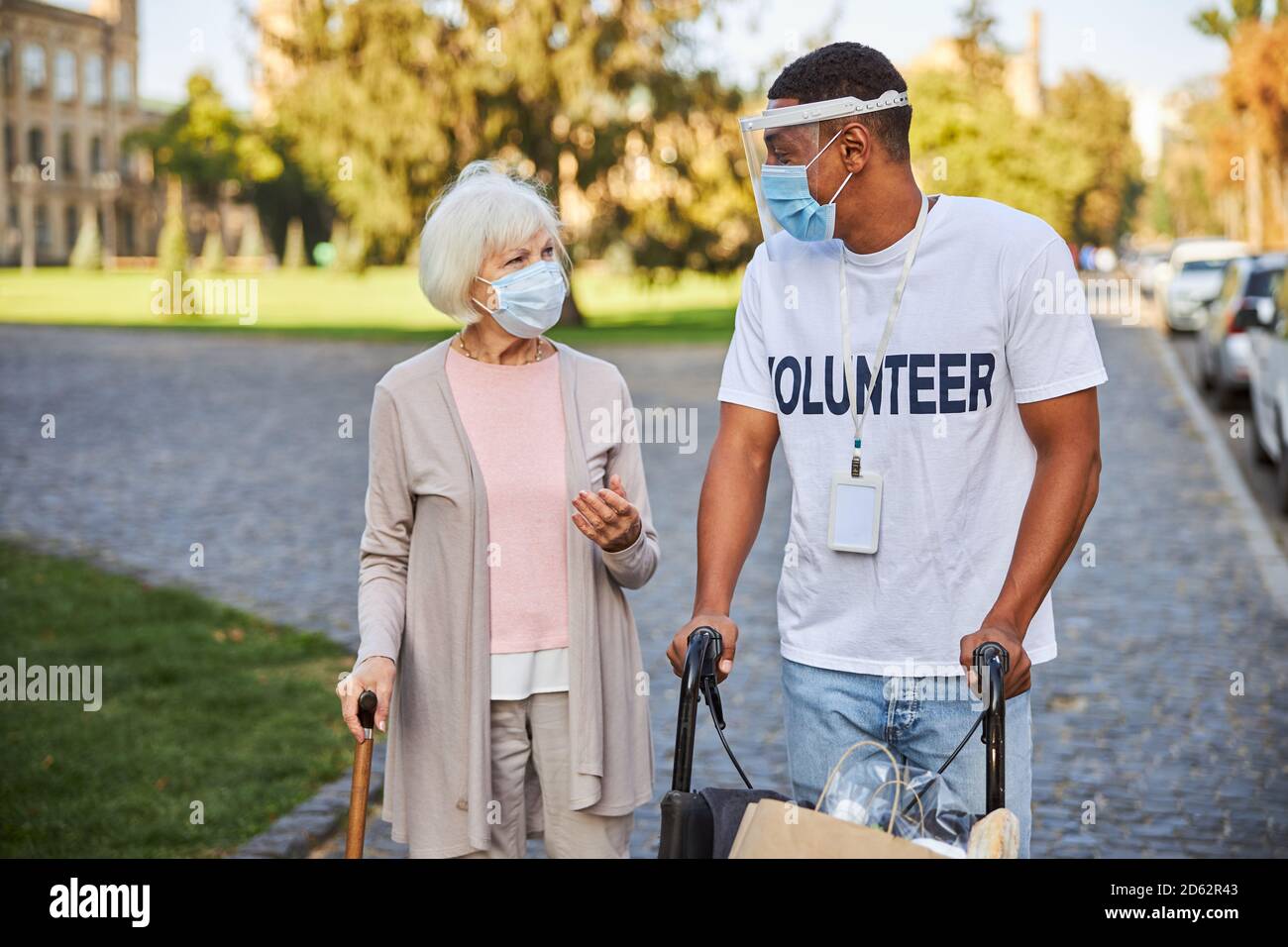 Aged lady improving mobility with helpful volunteer Stock Photo - Alamy