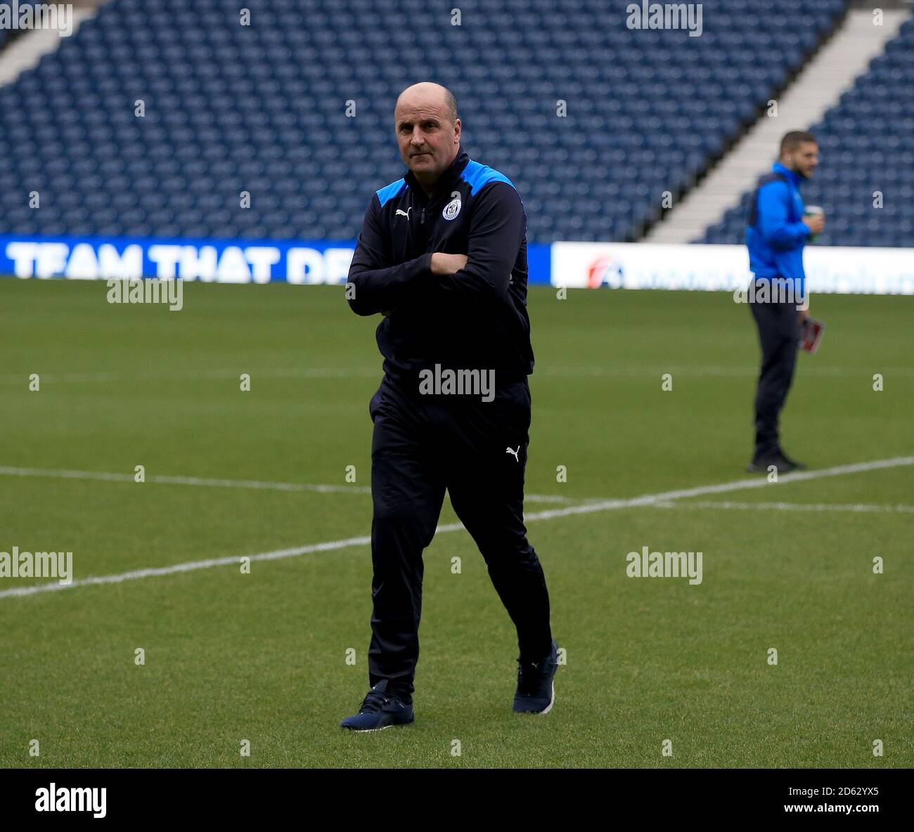 Wigan Athletic manager Paul Cook inspects the pitch before the Sky Bet ...