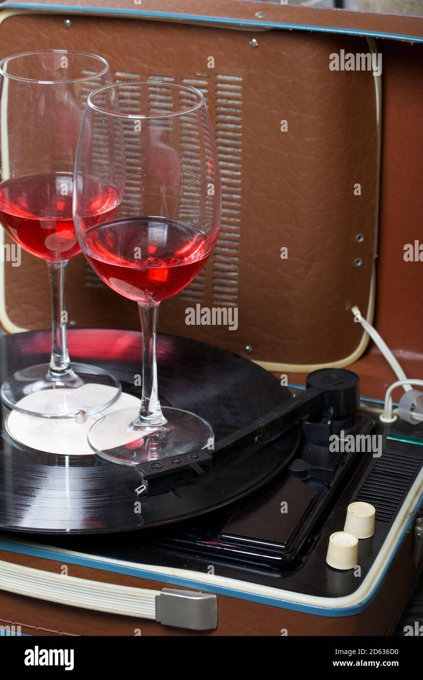 Old turntable. Nearby are two glasses of alcohol. Retro party equipment ...