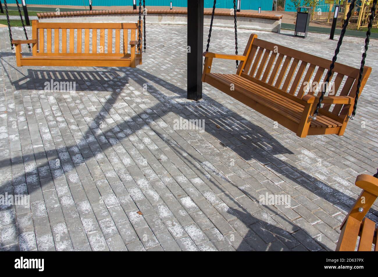 New swing bench in the park. Swing in the form of a wooden park bench ...
