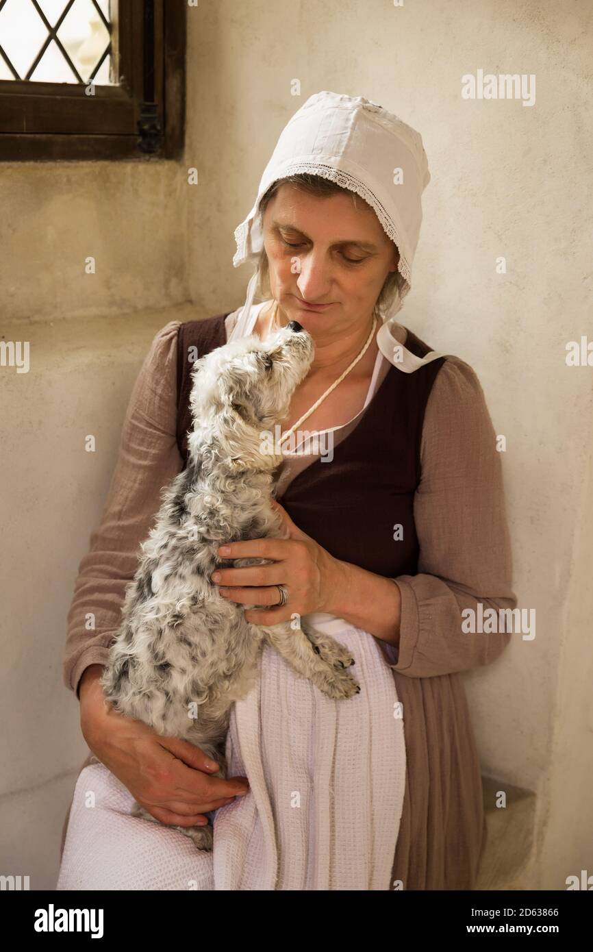 Woman in authentic medieval peasant outfit sitting with her dog in a ...