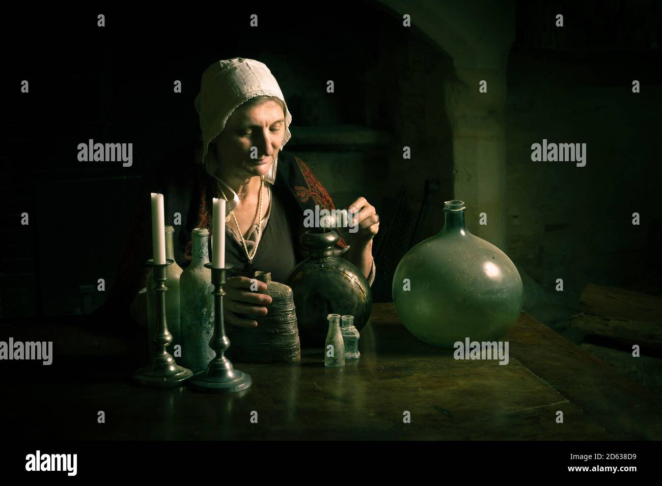 Woman in medieval outfit working as an alchemist or witch in the ...