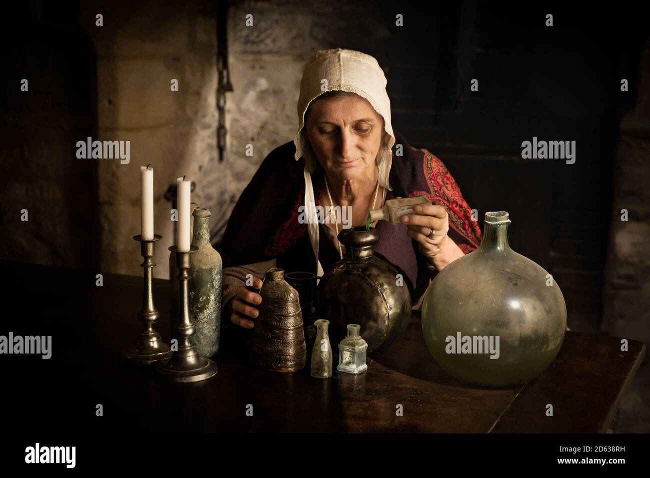 Woman in medieval outfit working as an alchemist or witch in the ...