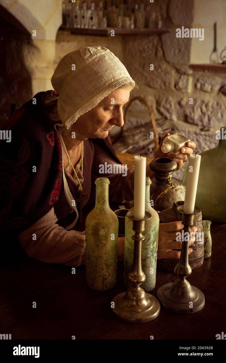 Woman in medieval outfit working as an alchemist or witch in the ...