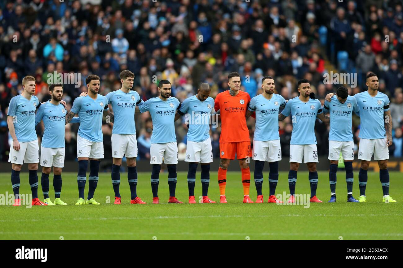 Manchester City players line up to observe a minute's silence in honour ...