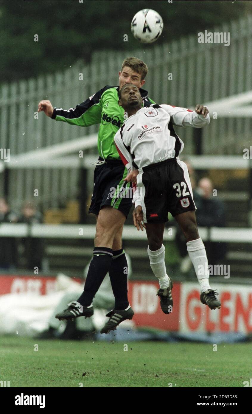 Darlington's Clint Marcelle battles for the ball in the air with ...