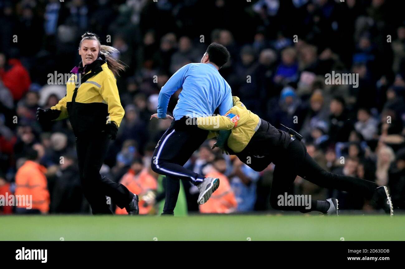 Security tackle a pitch invader at the end of the match Stock Photo - Alamy