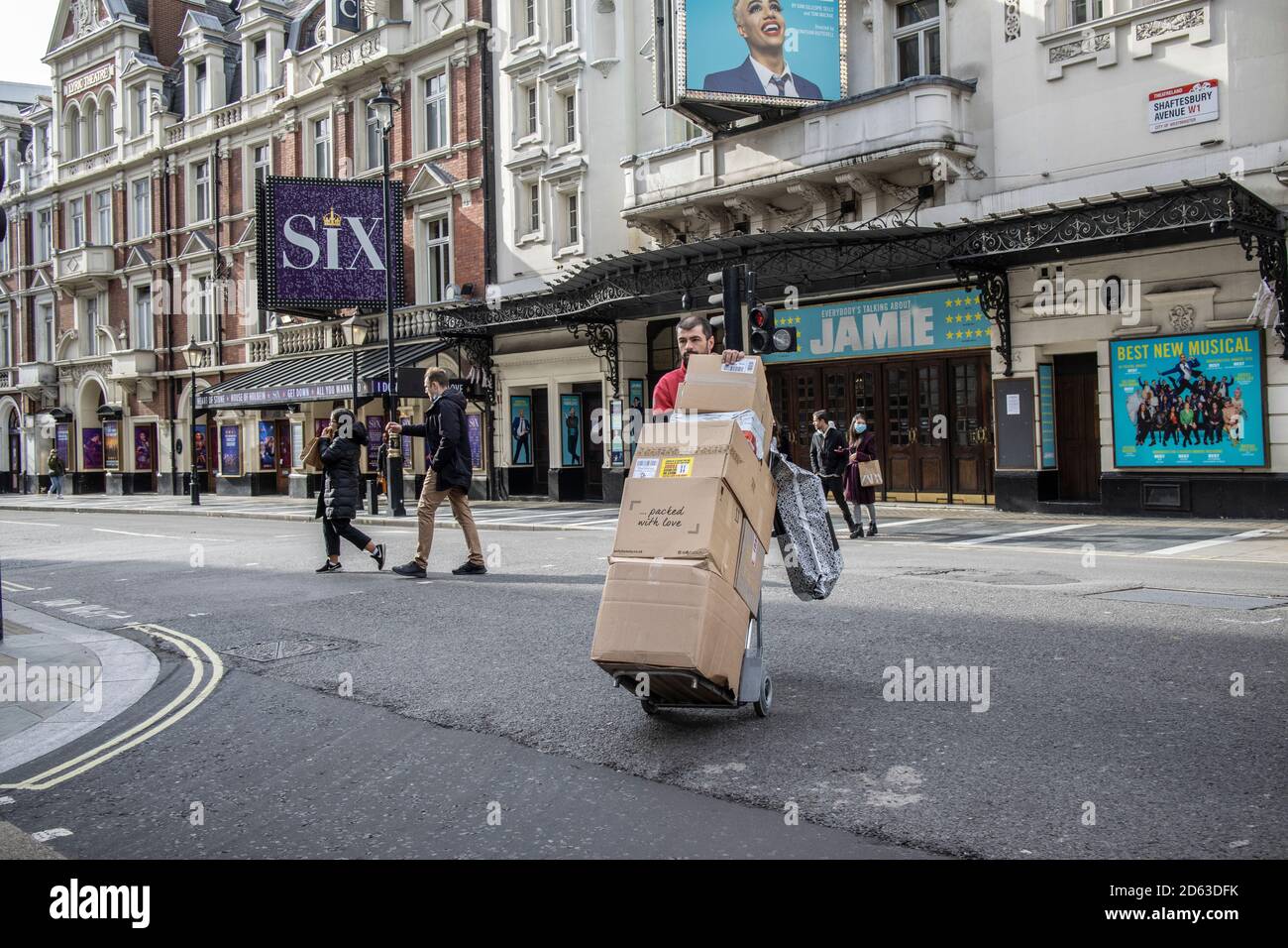 Courier delivering boxes on a trolley to businesses on Shaftesbury ...