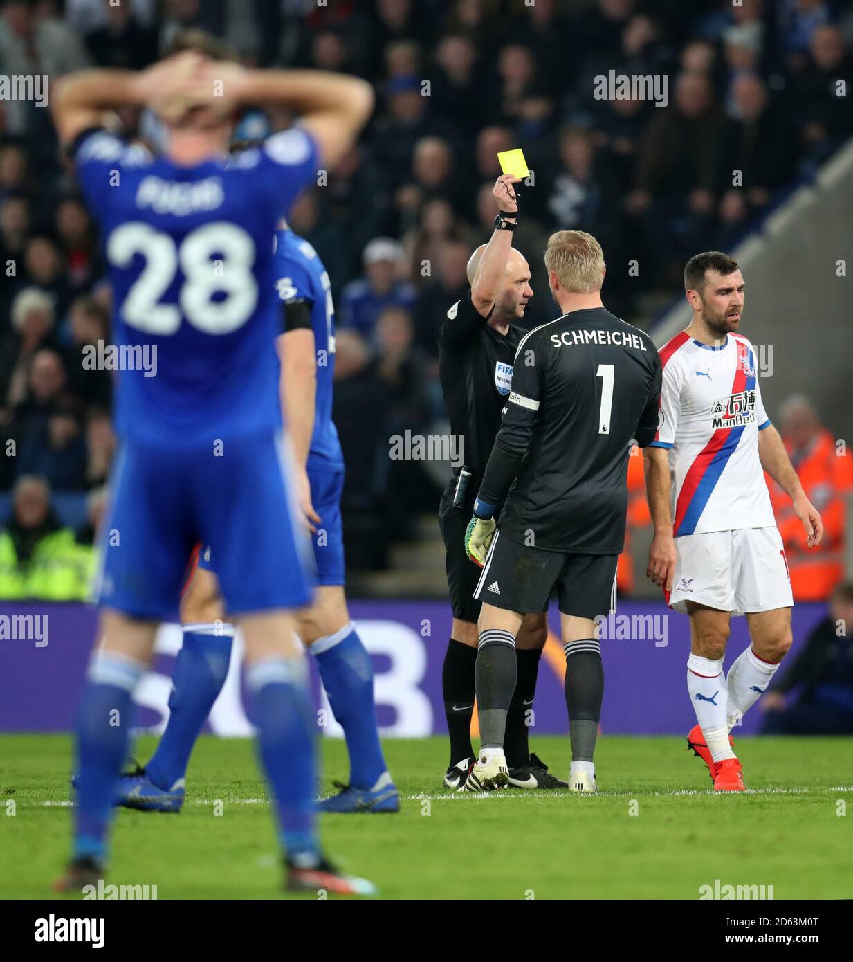 Leicester City goalkeeper Kasper Schmeichel is shown a yellow card by ...