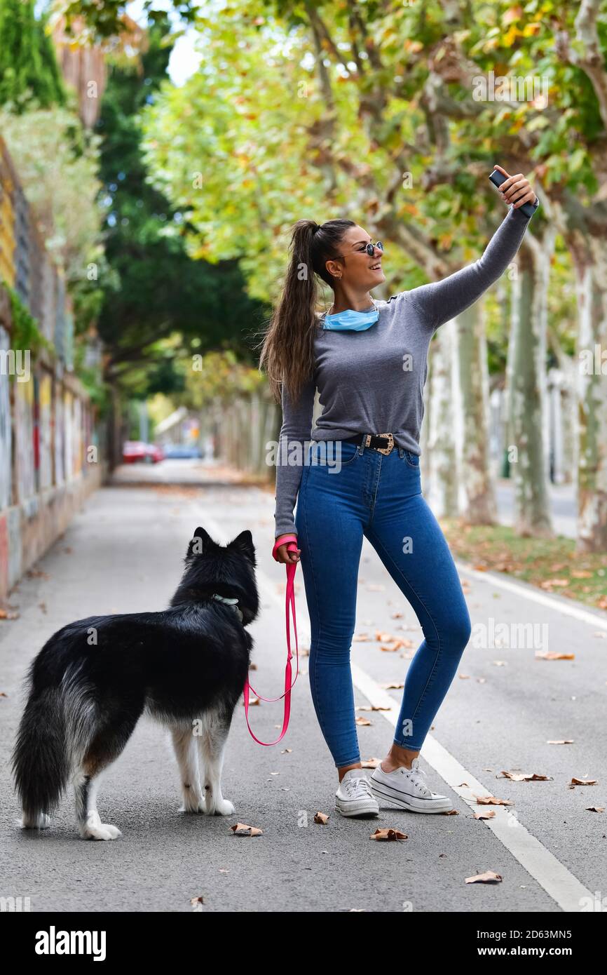 Beautiful woman with a surgical mask pulled down taking a photo of ...