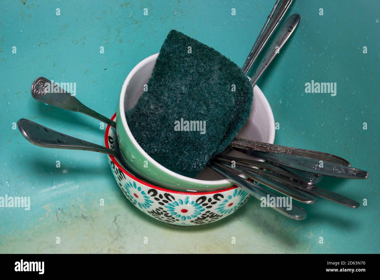 Dirty Dishes Piled up with Spoons and Sponge in Sink Stock Photo - Alamy
