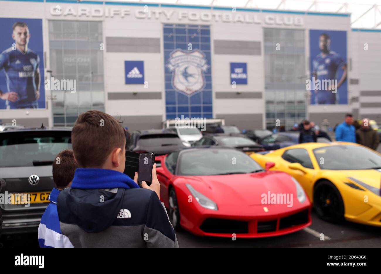 Fans take pictures and look at Ferrari's parked in the car park at the ...