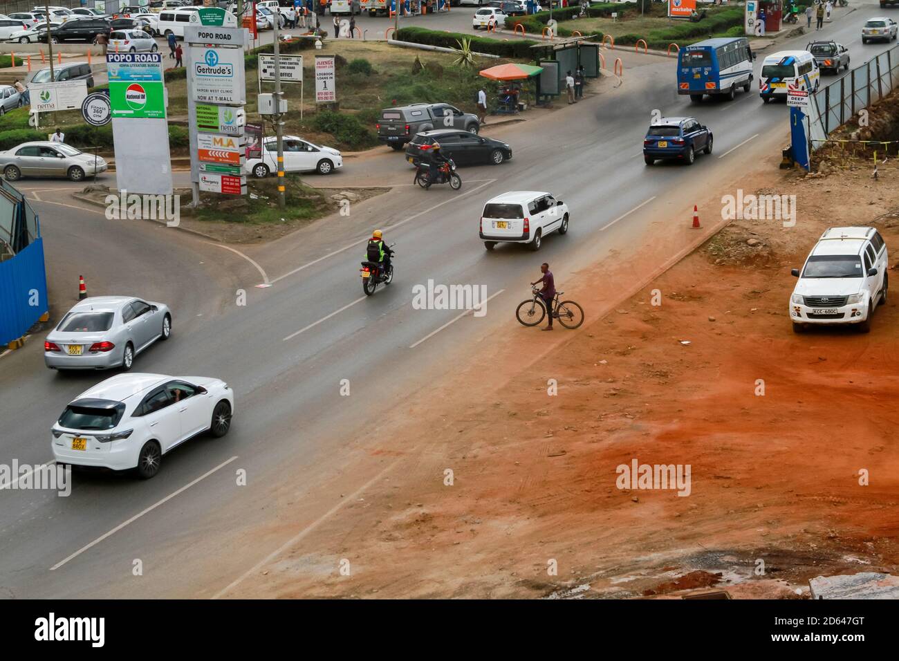 A cyclist waiting to cross the road on Section 2 of the Nairobi ...