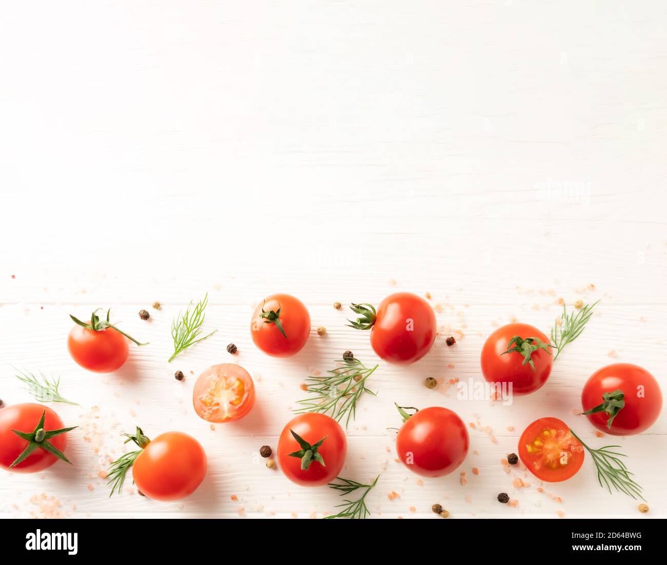 Fresh ripe cherry tomatoes with dill, salt and pepper on a white wooden ...