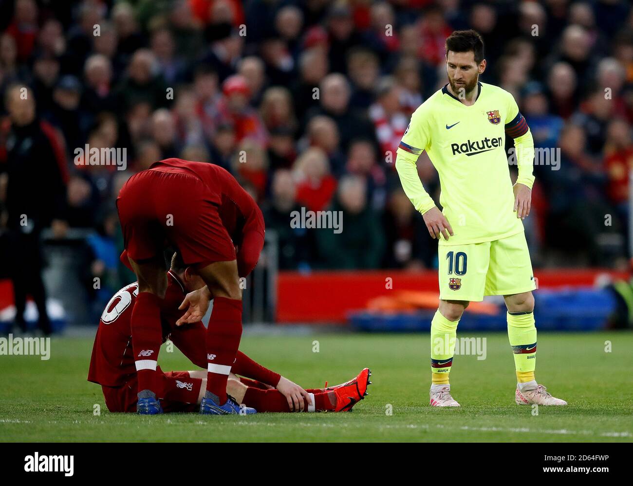 Barcelona's Lionel Messi (right) looks at Liverpool's Andrew Robertson ...