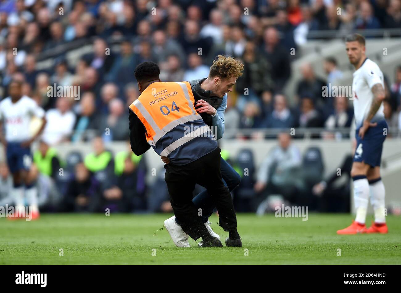 A pitch invader is assorted off the pitch by stewards Stock Photo - Alamy