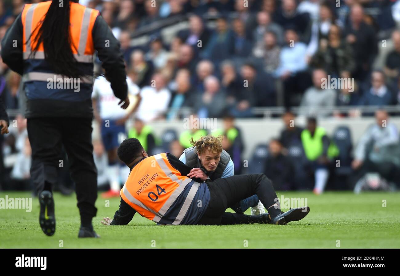 A pitch invader is assorted off the pitch by stewards Stock Photo - Alamy