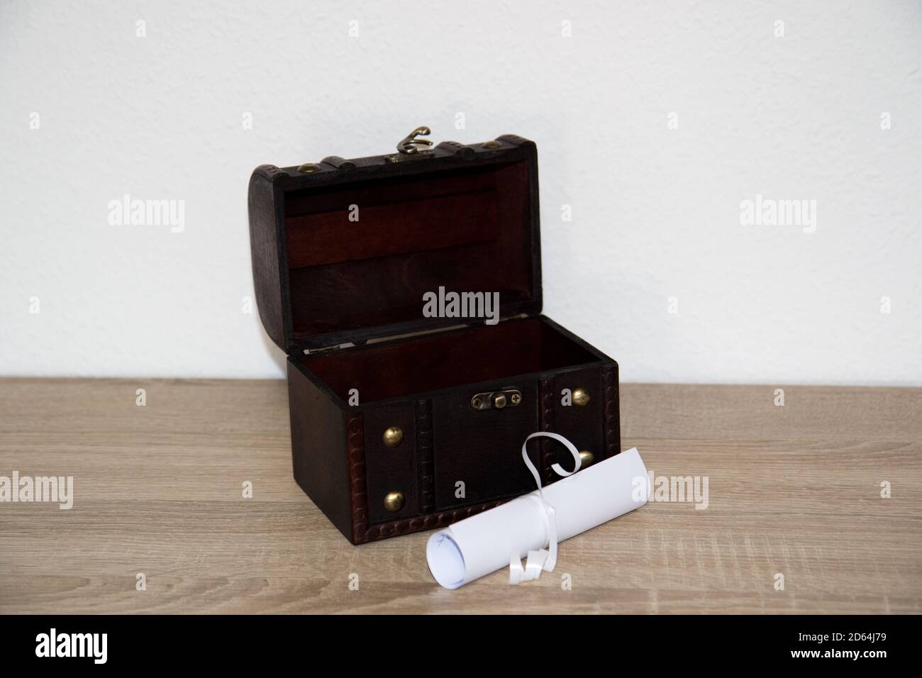 Opened treasure chest next to a blank rolled paper Stock Photo - Alamy