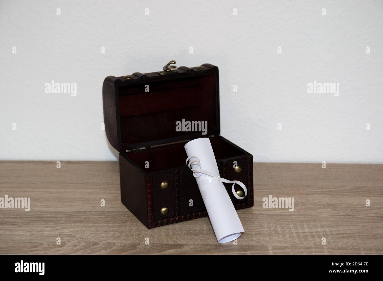 Opened treasure chest next to a blank rolled paper Stock Photo - Alamy