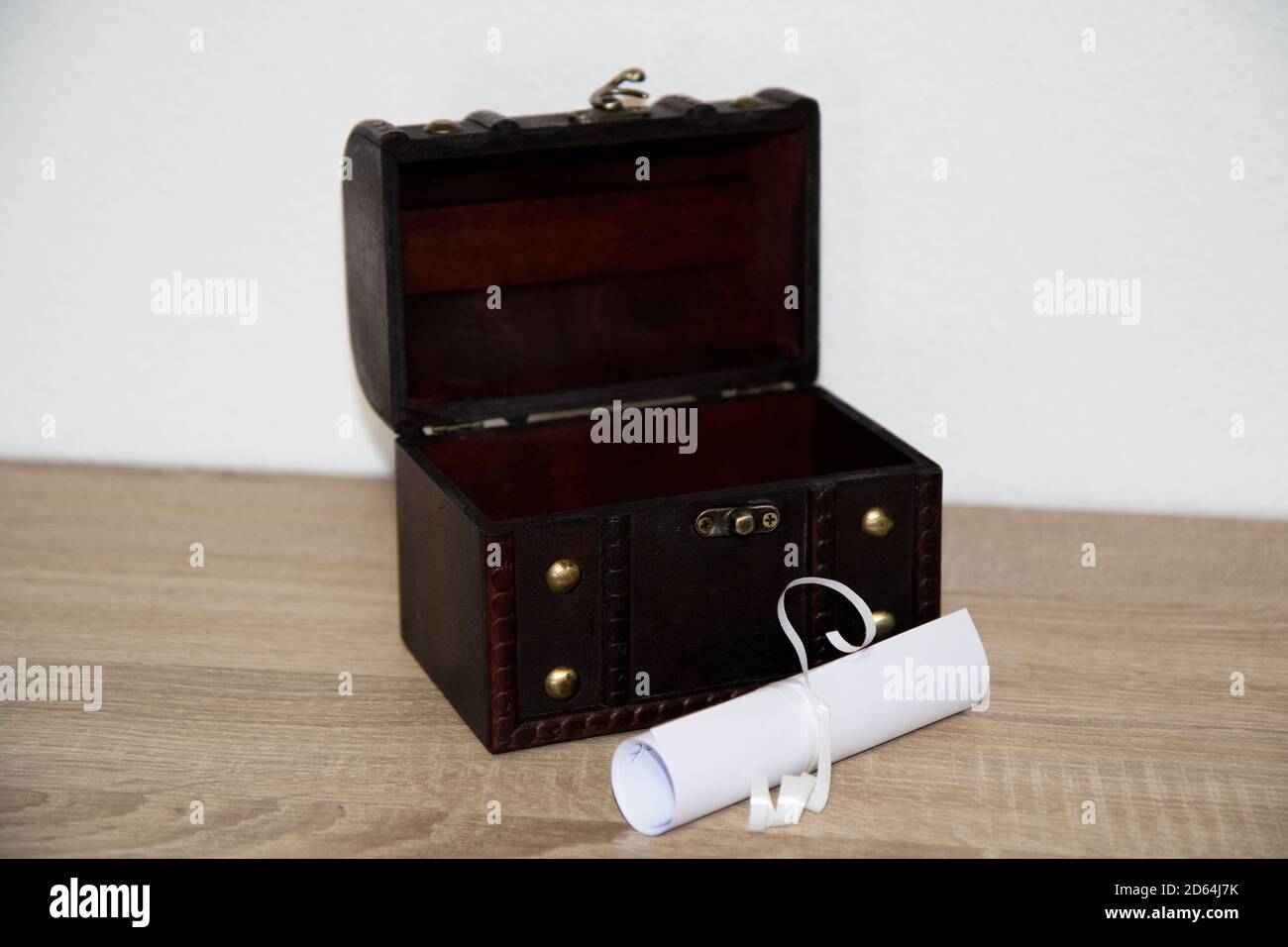 Opened treasure chest next to a blank rolled paper Stock Photo - Alamy
