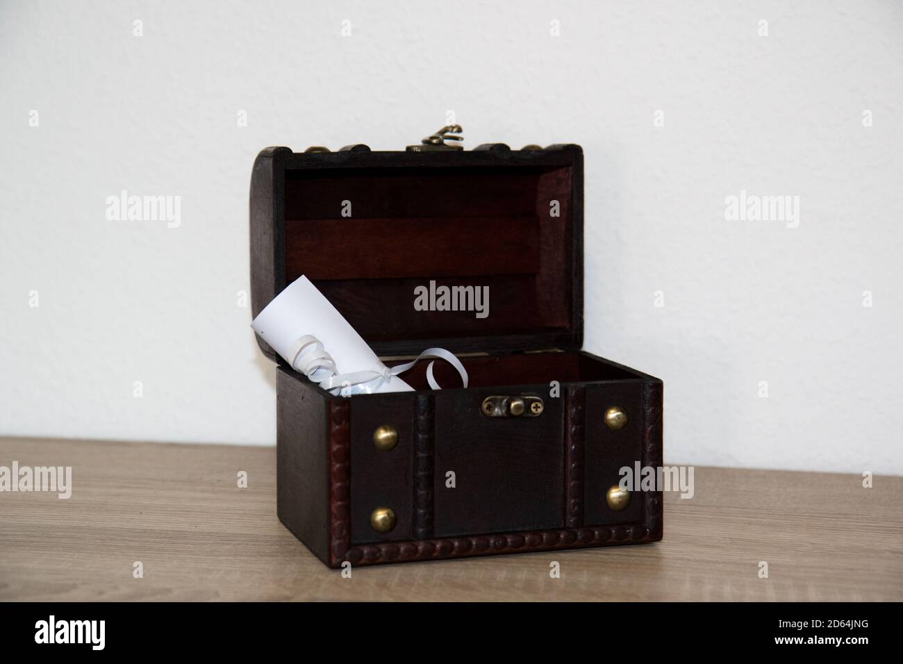Treasure chest with a rolled blank paper inside of it Stock Photo - Alamy