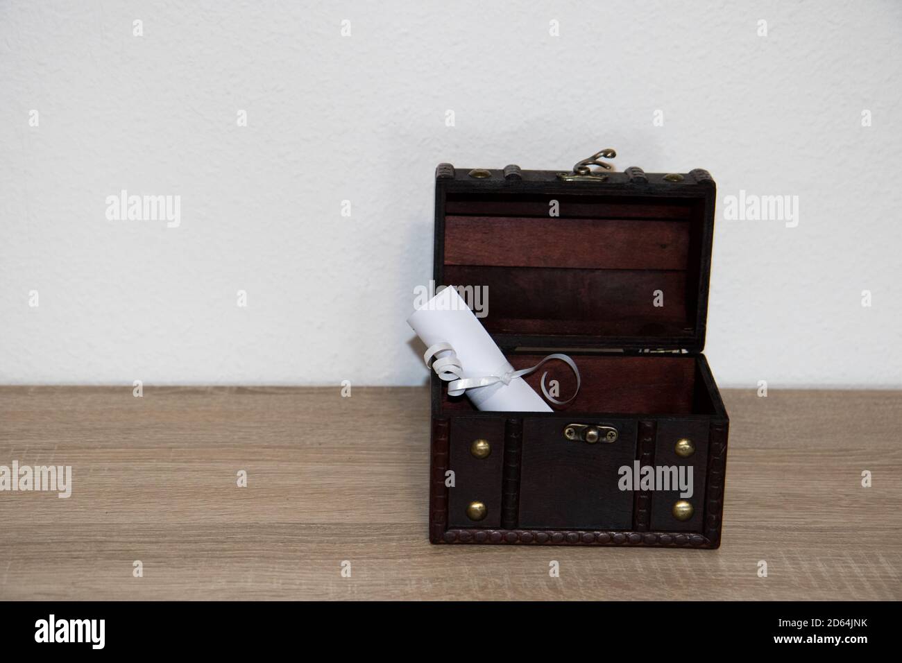 Treasure chest with a rolled blank paper inside of it Stock Photo - Alamy