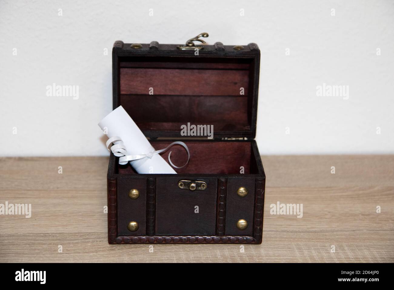 Treasure chest with a rolled blank paper inside of it Stock Photo - Alamy
