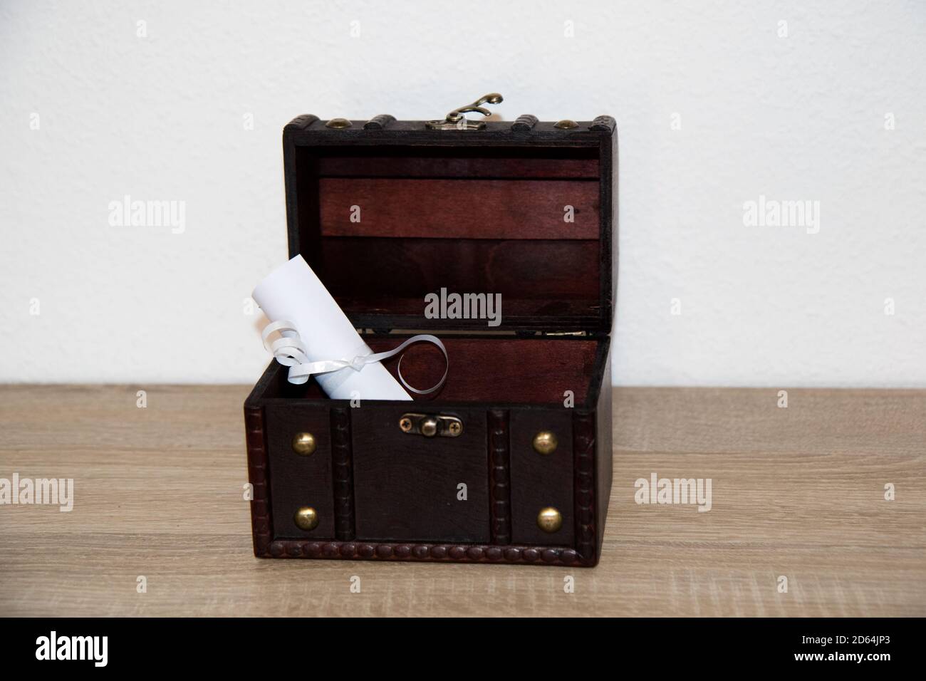 Treasure chest with a rolled blank paper inside of it Stock Photo - Alamy