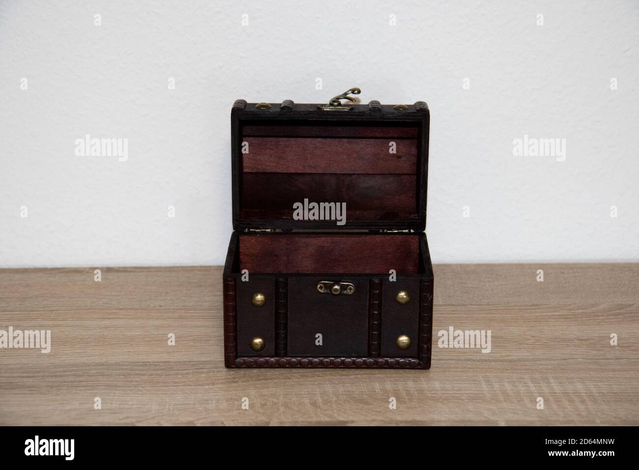 Opened brown treasure chest on a wooden surface Stock Photo - Alamy