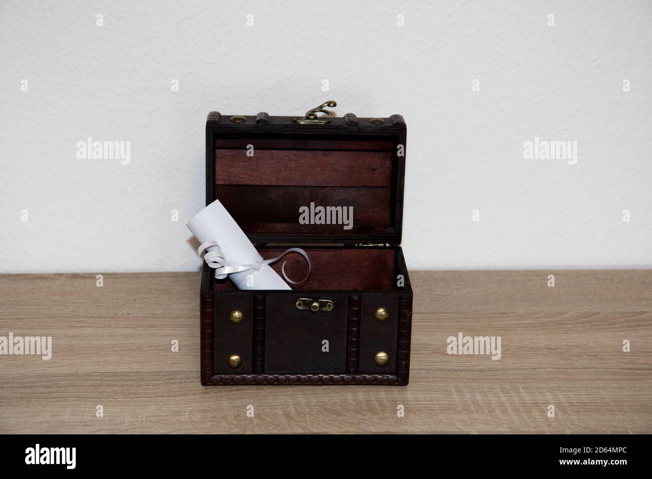 Treasure chest with a rolled blank paper inside of it Stock Photo - Alamy