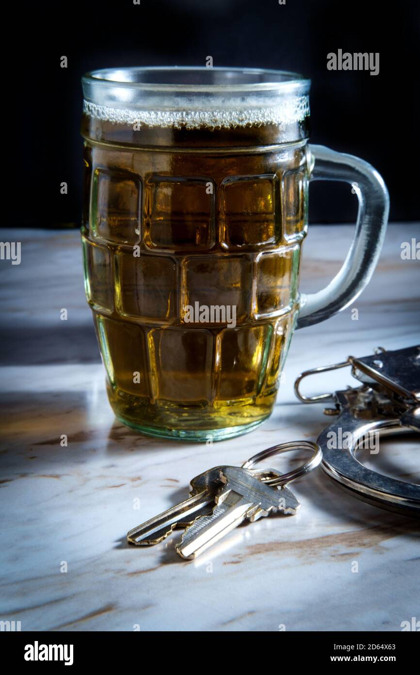 Mug of beer with handcuffs and keys symbolizing drunk driving arrest ...