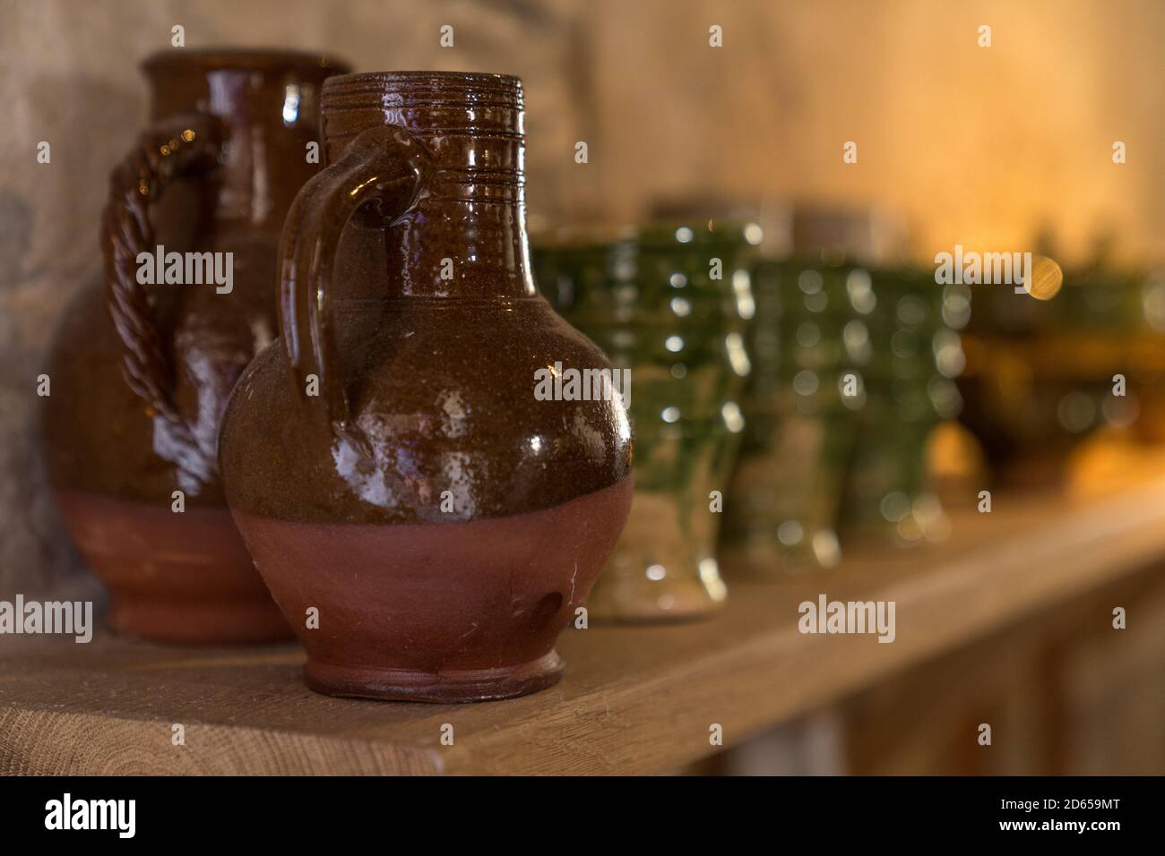 Many medieval earthenware jugs and cups in brown and green glazing ...
