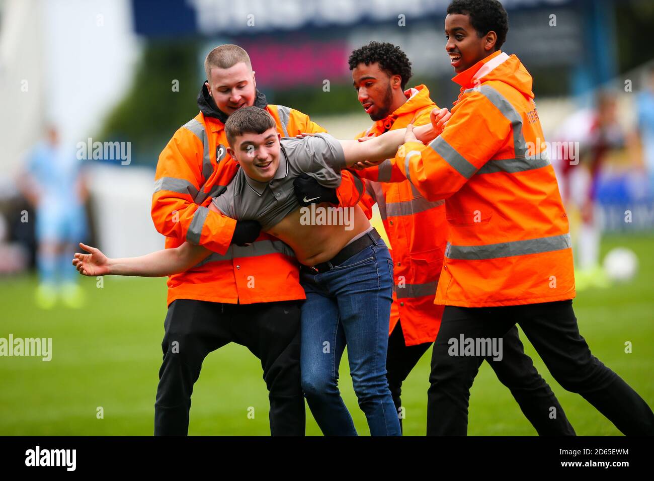 A fan is restrained after invading the pitch Stock Photo - Alamy
