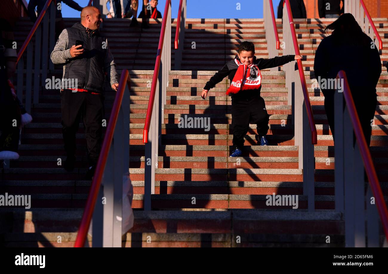 A young Liverpool fan runs down steps outside the ground ahead of the ...