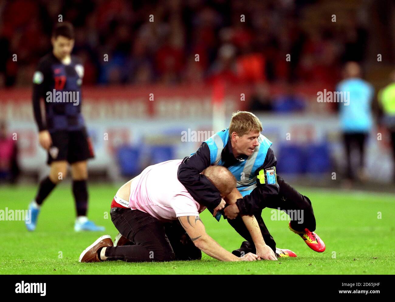 A steward catches a pitch invader during the match Stock Photo - Alamy